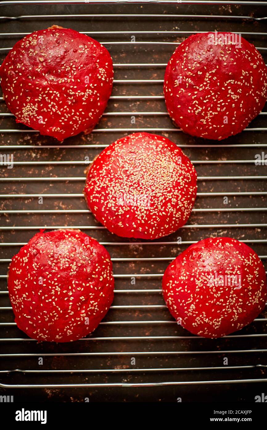 Fresh baked red homemade burger buns with sesame top view. Placed on ...
