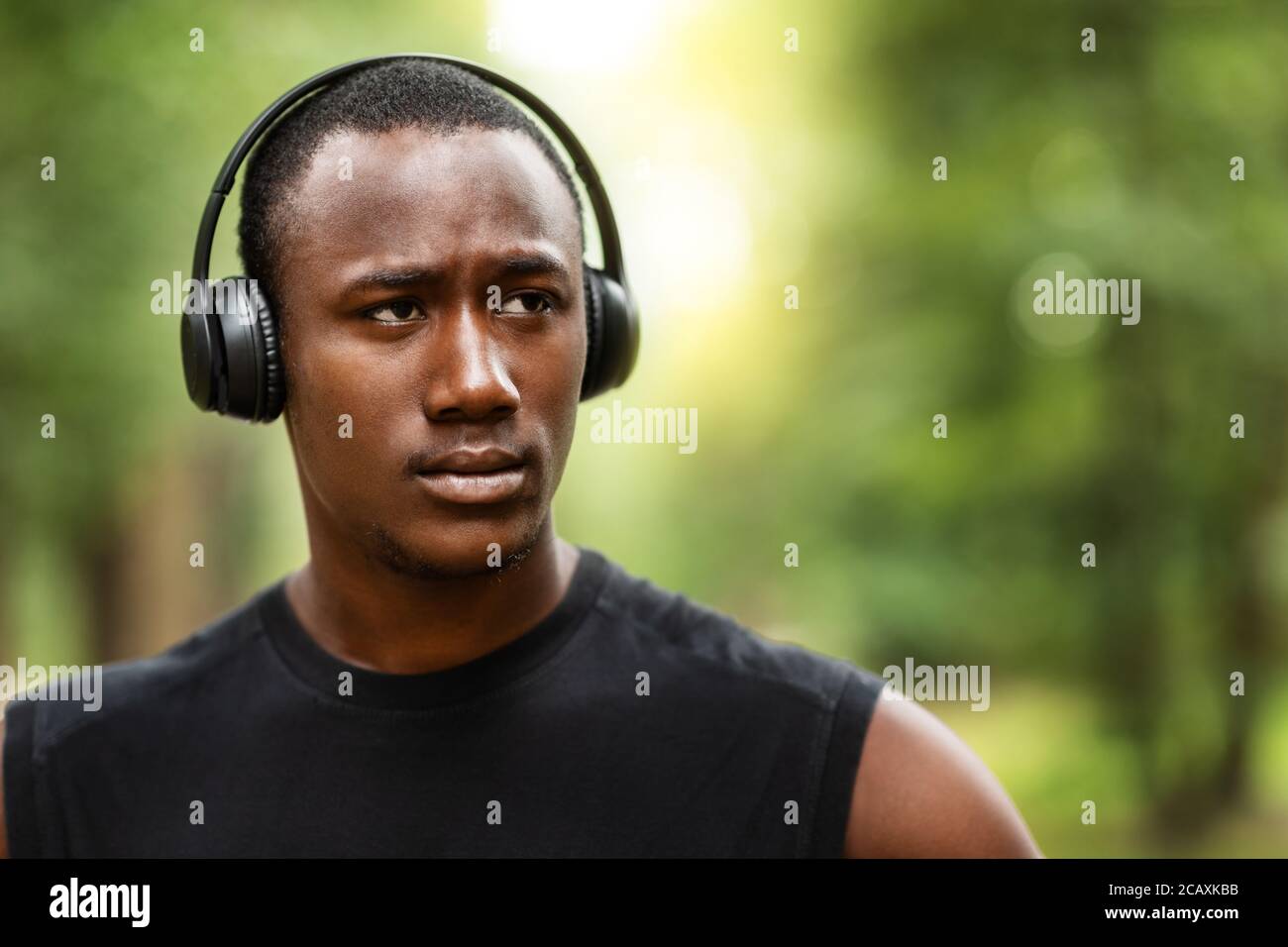 Portrait of concentrated black guy with wireless headset, training ...