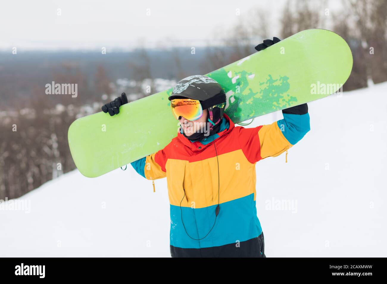 tired man with a snowboard on his neck outdoors. close up photo ...
