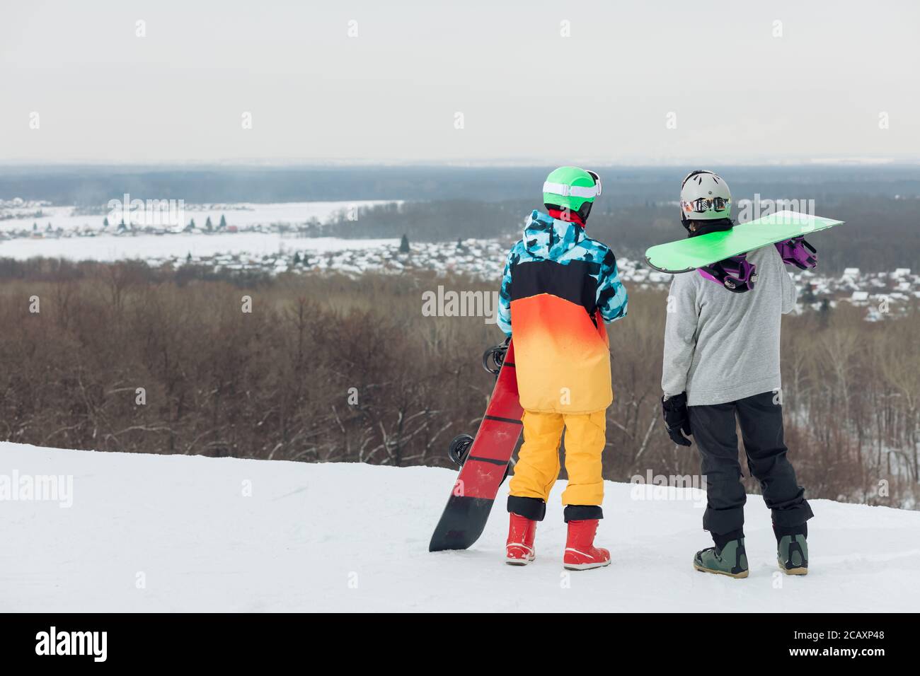 two best friends are talking while resting after snowboarding ...