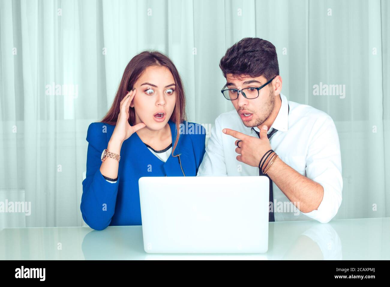 Shocking news. Two surprised couple coworkers colleagues man and woman ...