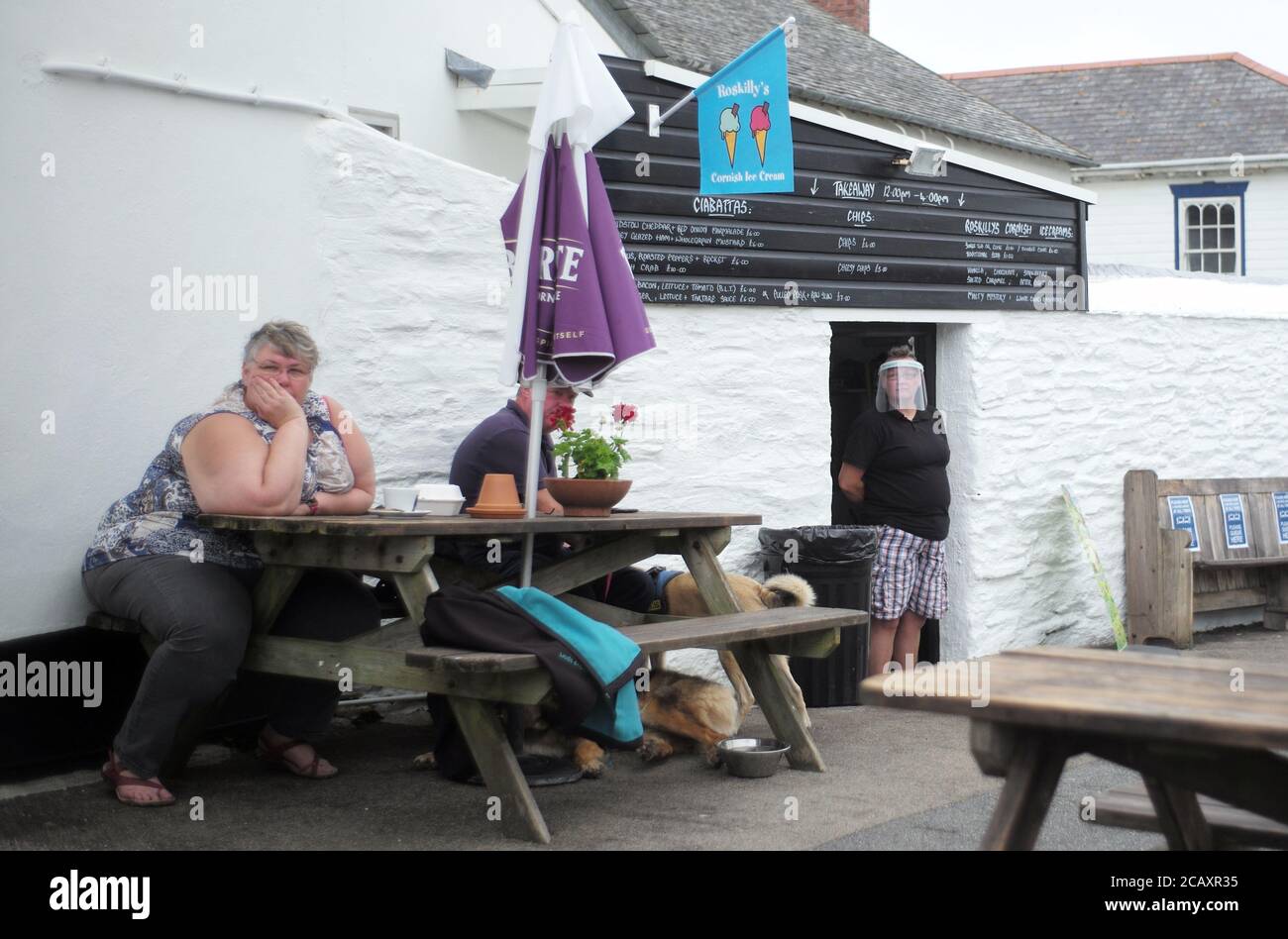 A pub worker awaits a delivery as she wears a face mask while standing ...