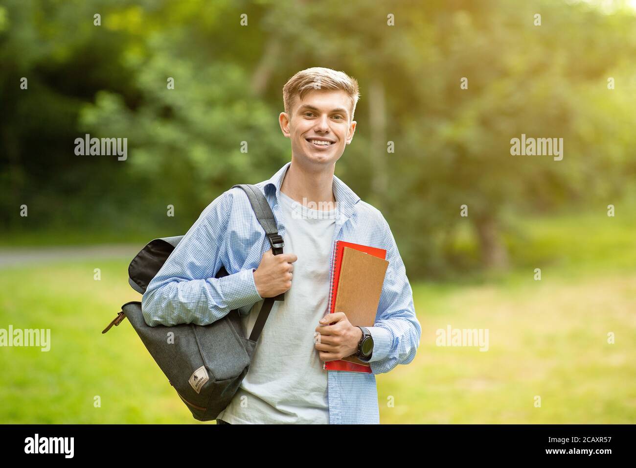 Portrait Of Handsome University Student Guy With Backpack And Workbooks ...
