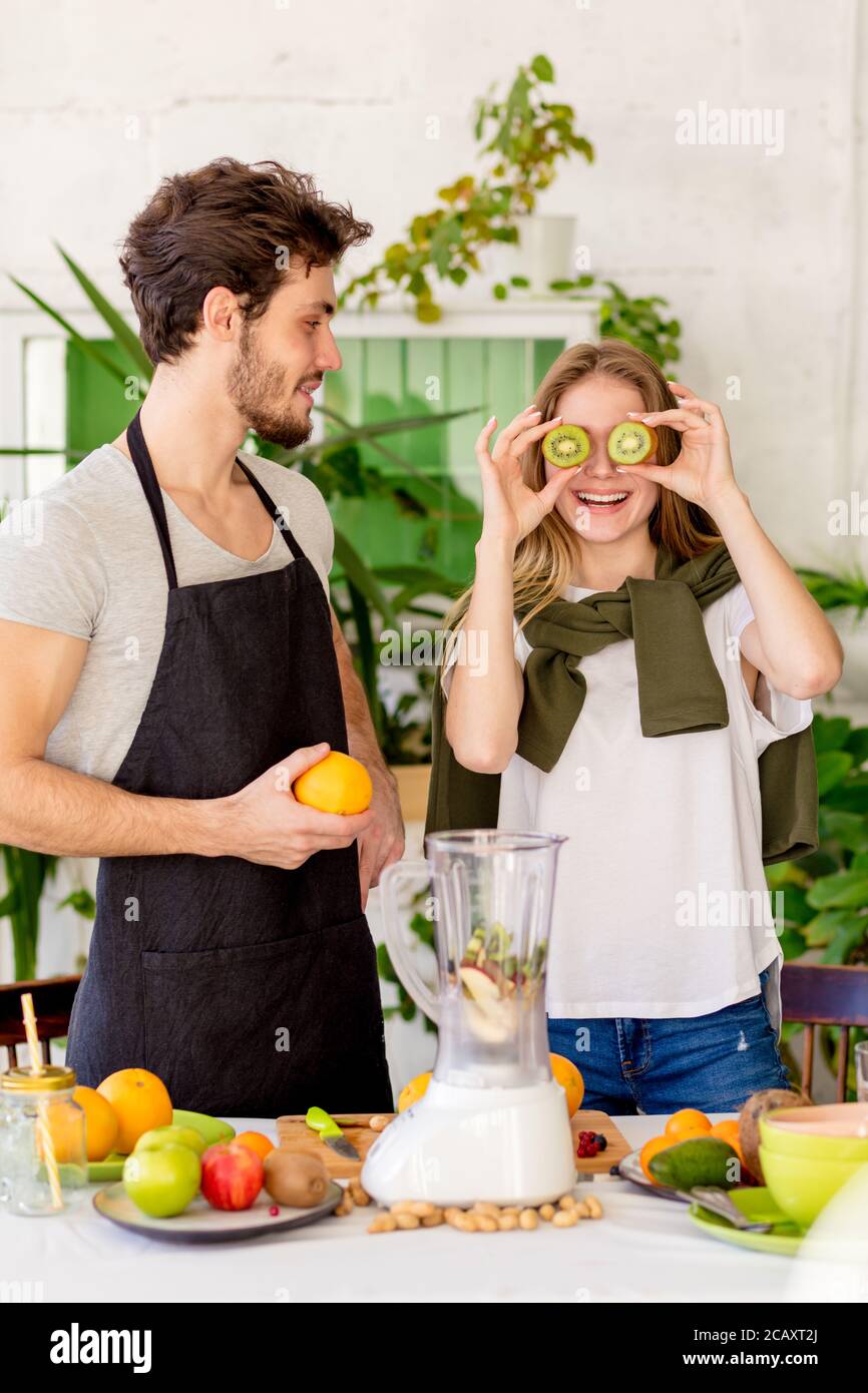good looking funny girl has made glasses from kiwi. girl is having fun ...