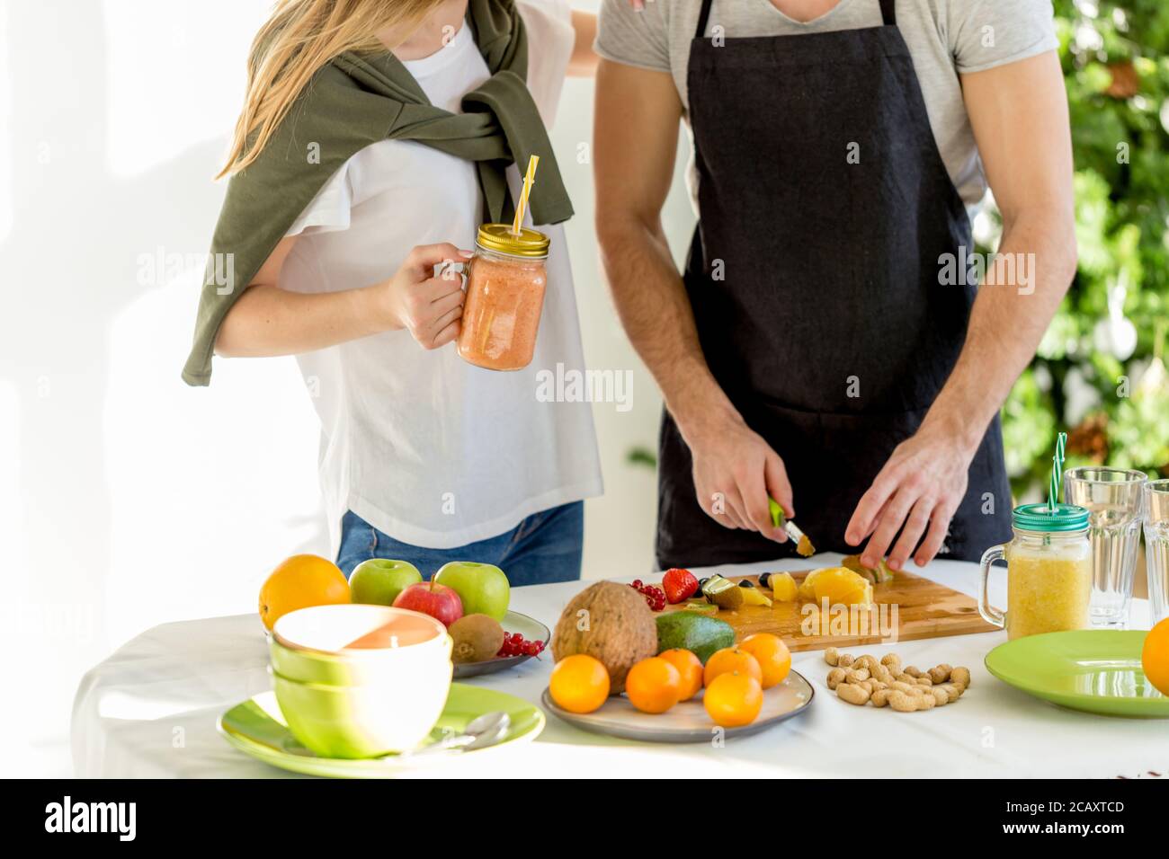 fruit mix on the table. two people making nutritious snakcs. cropped ...