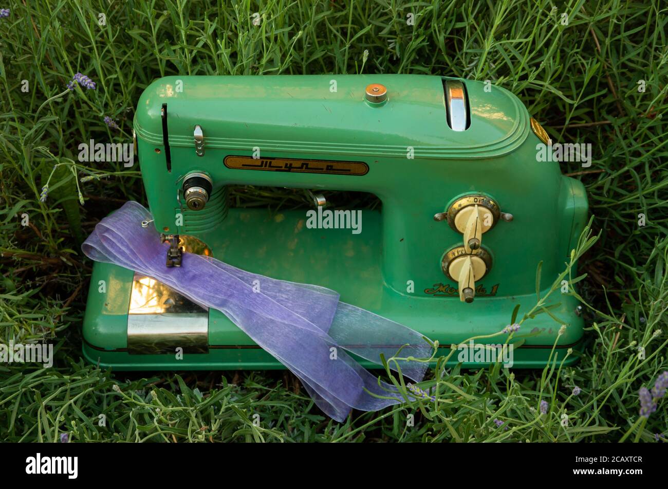 Green old, retro green sewing machine with purple fabric, finger job ...