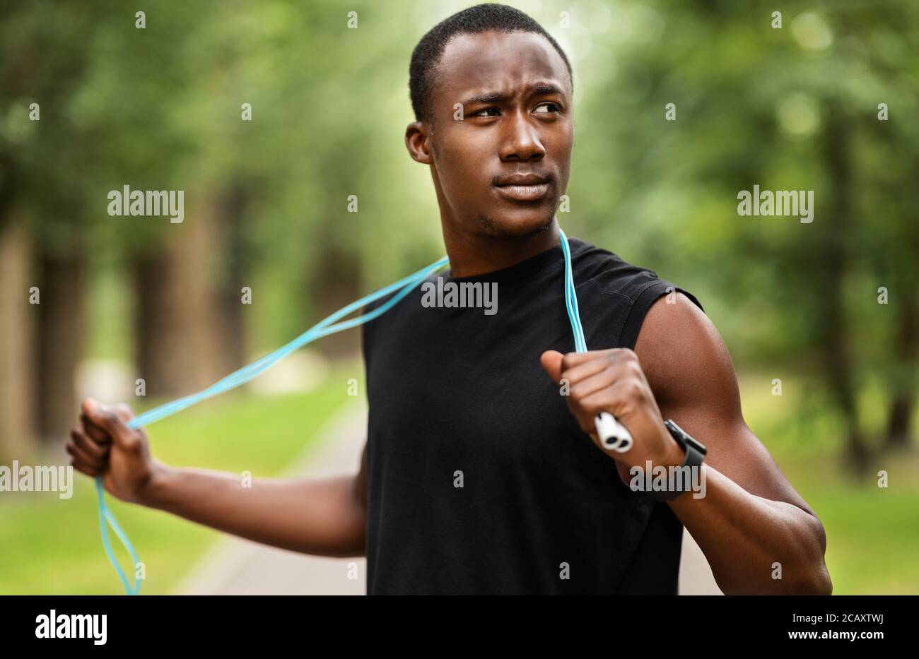 Concentrated sporty black guy with jumping rope training at park Stock ...