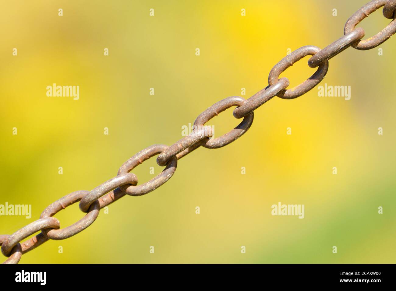 Old metal chain on a blurred yellow background Stock Photo - Alamy