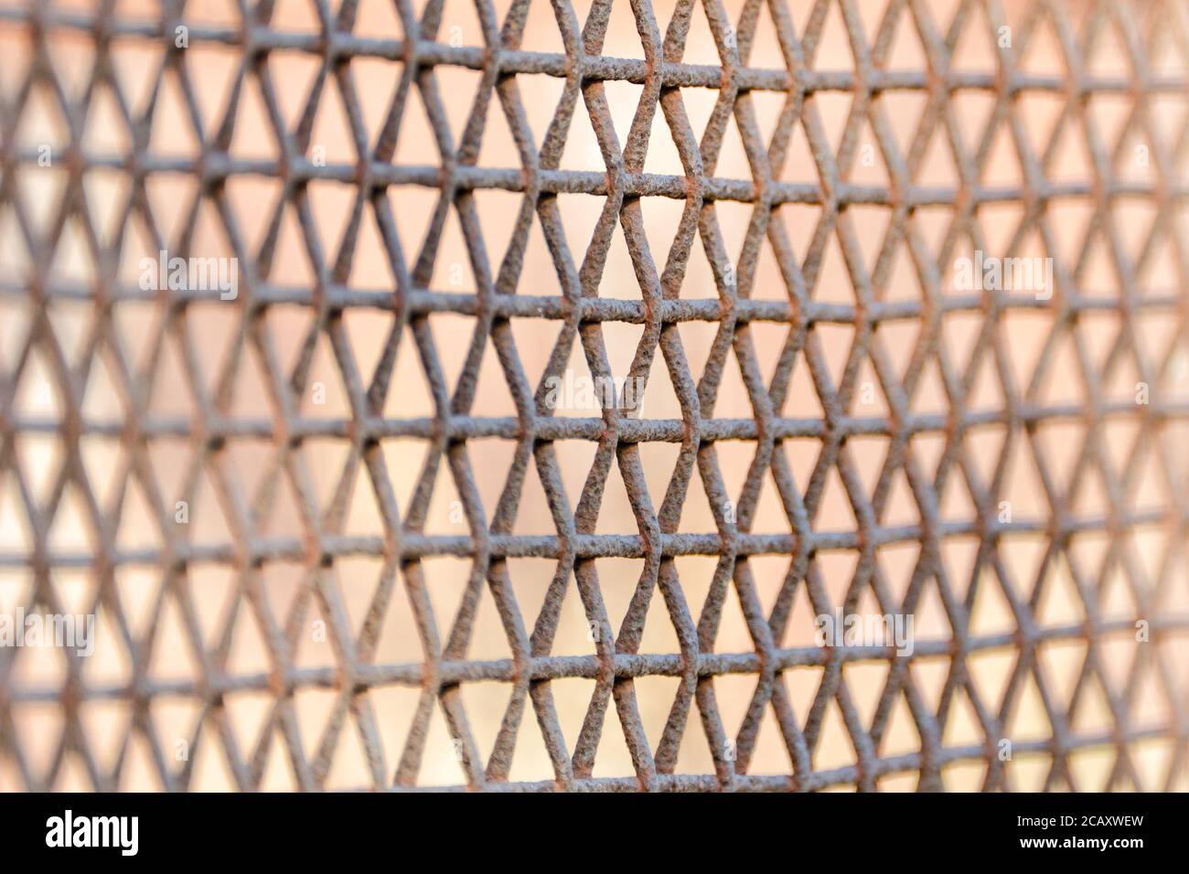 Rusty fence made of metal mesh, rhombic cells. Soft focus. Side view ...