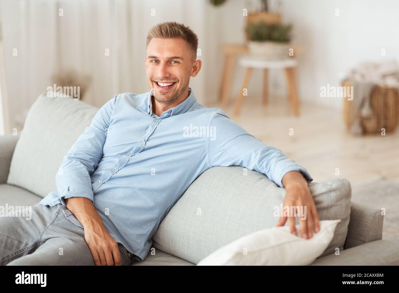 Guy having rest at home on his sofa Stock Photo - Alamy