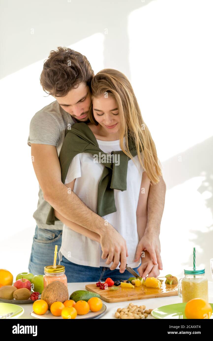pretty couple cooking healthy food in the morning. isolated white ...
