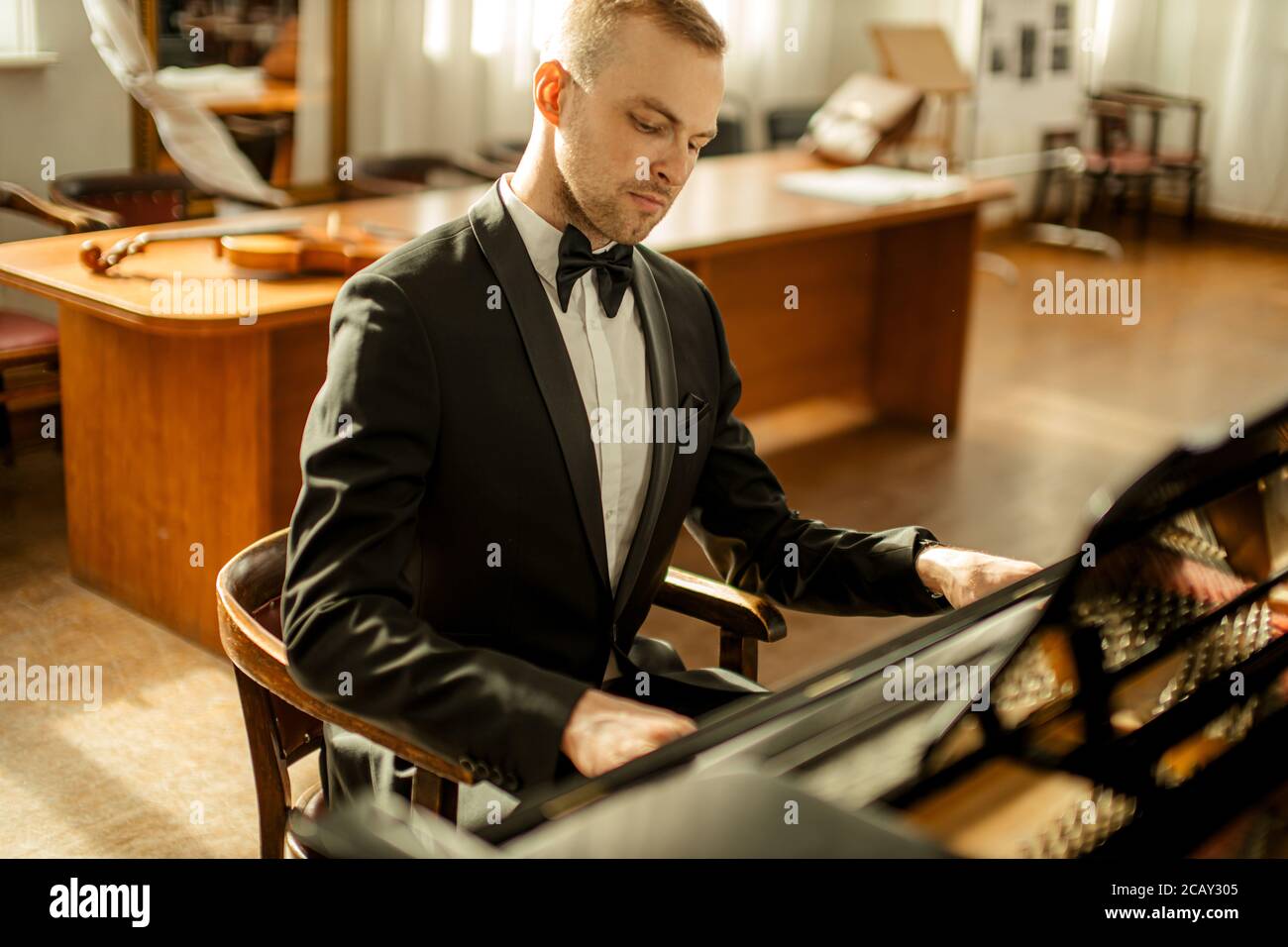 young talented male in formal suit professionally play piano. classical ...