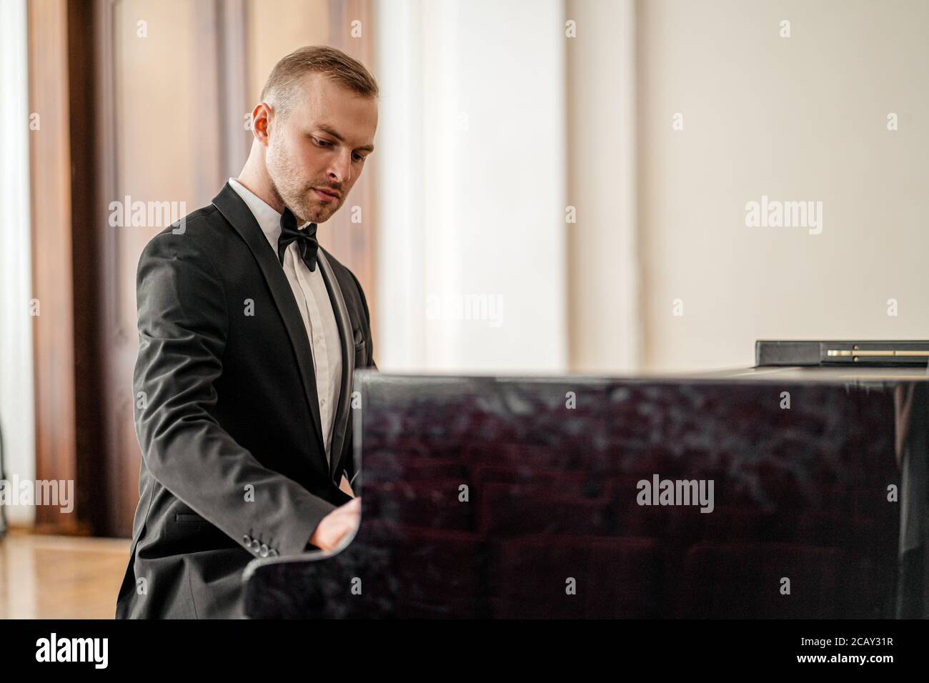 professional caucasian pianist practicing before concert on a stage ...