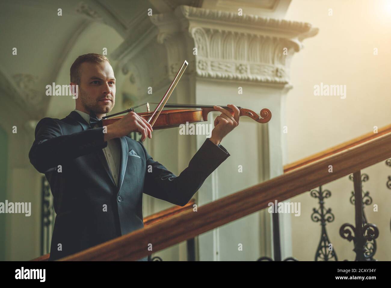 young caucasian talented violinist play violin, handsome guy in formal ...