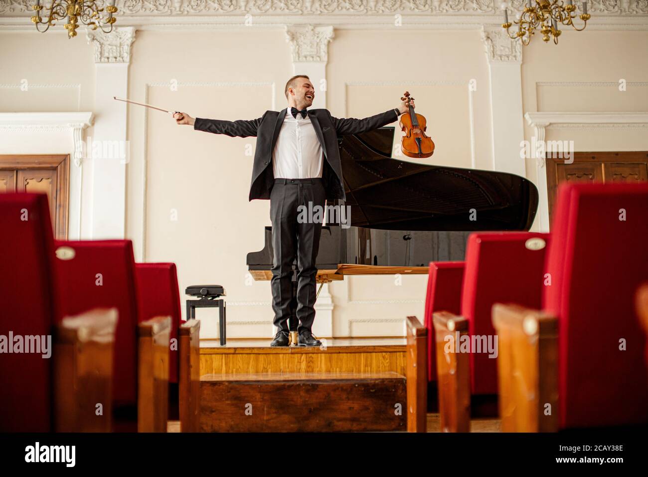 handsome caucasian male violinist in suit in the end of performance ...