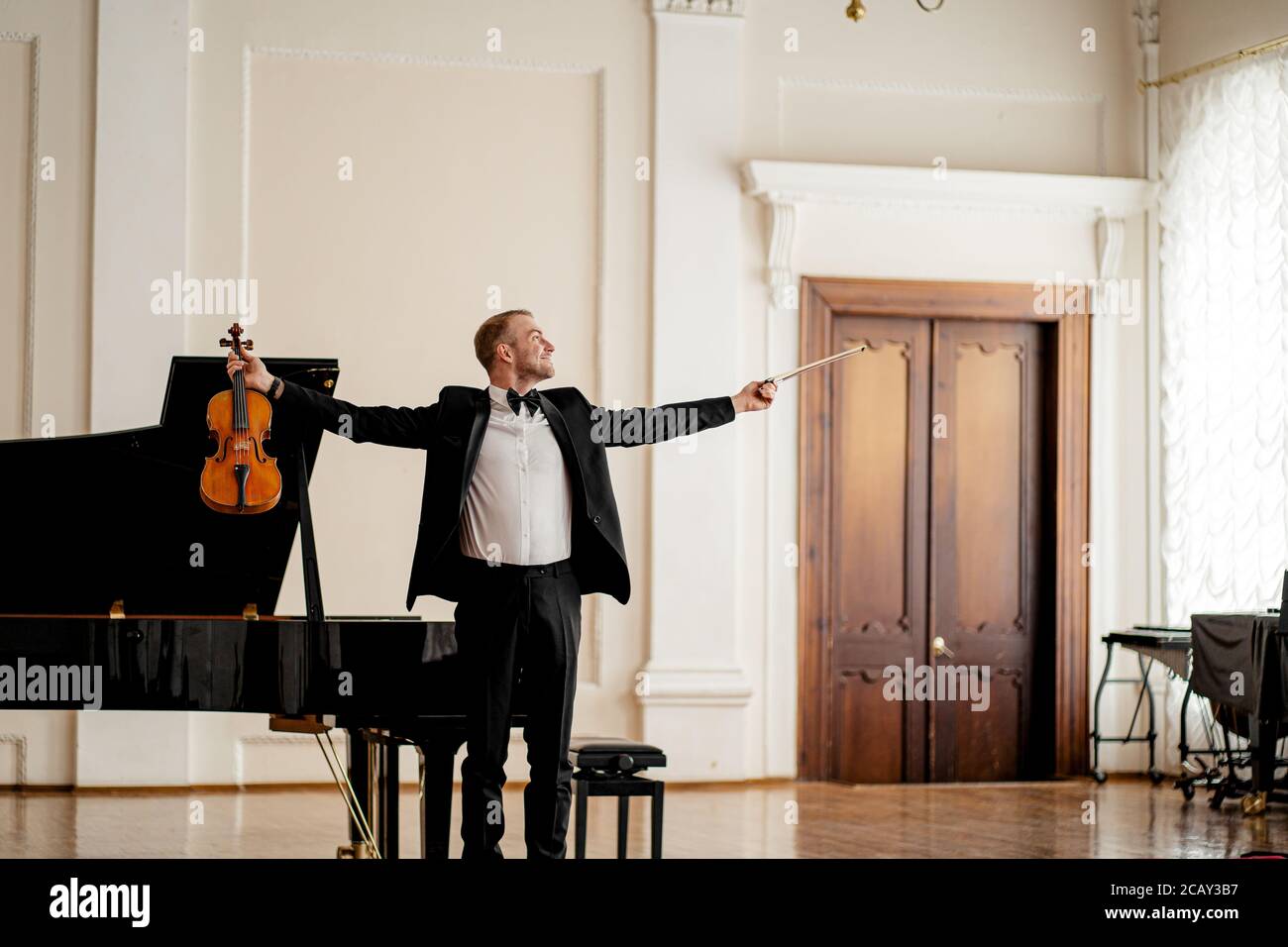 professional male musician with violin on a stage, violinist thanks ...