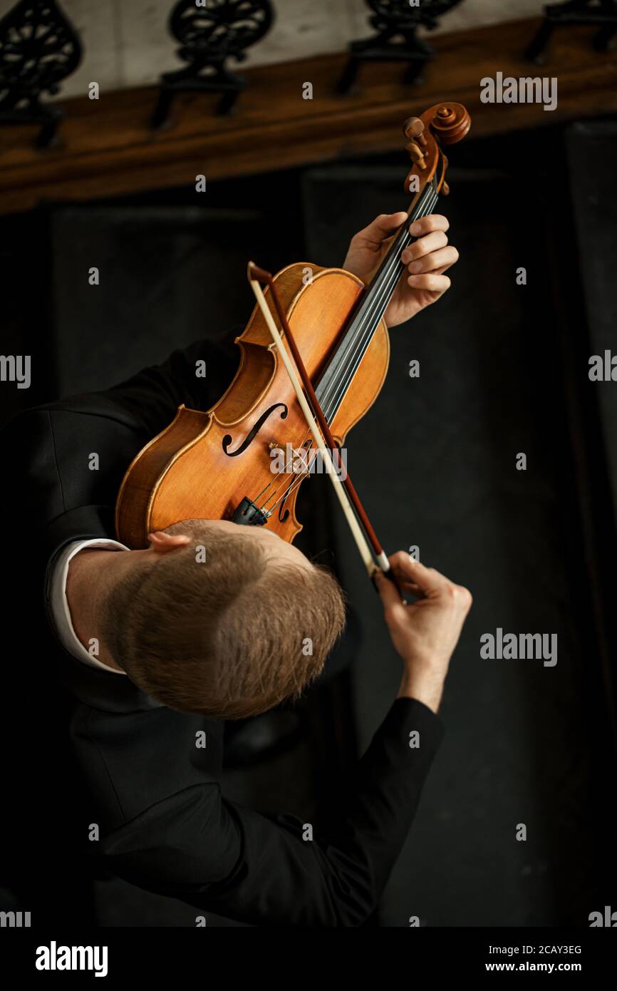 top view on young male violinist performing music, man gracefully play ...