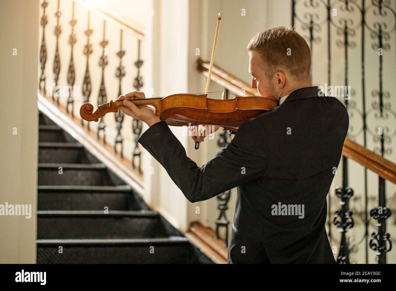 young caucasian talented violinist play violin, handsome guy in formal ...