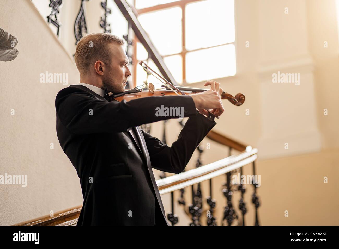 handsome caucasian guy with classic instrument violin, talented male ...