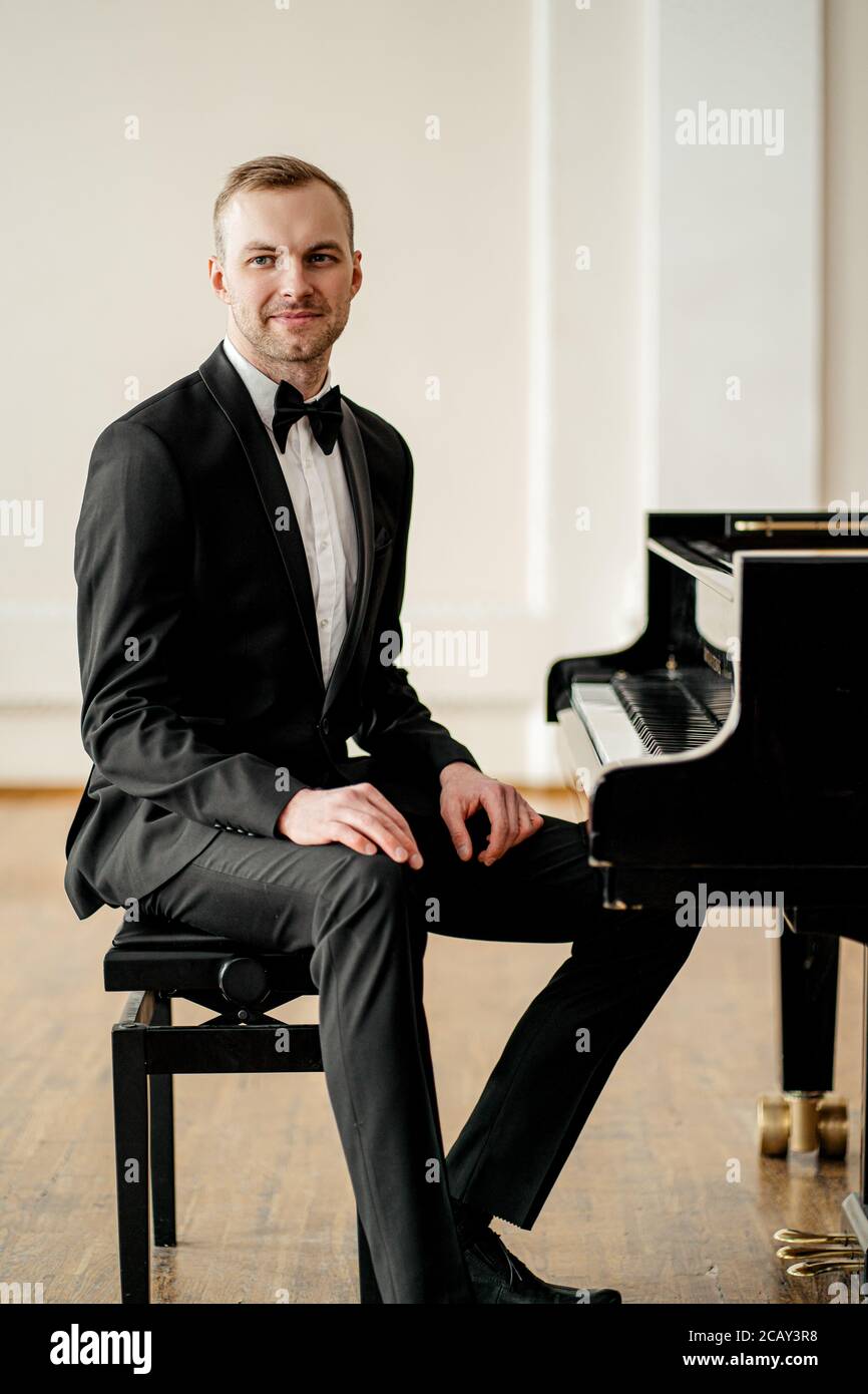 talented caucasian male pianist sit, look at camera and smile ...