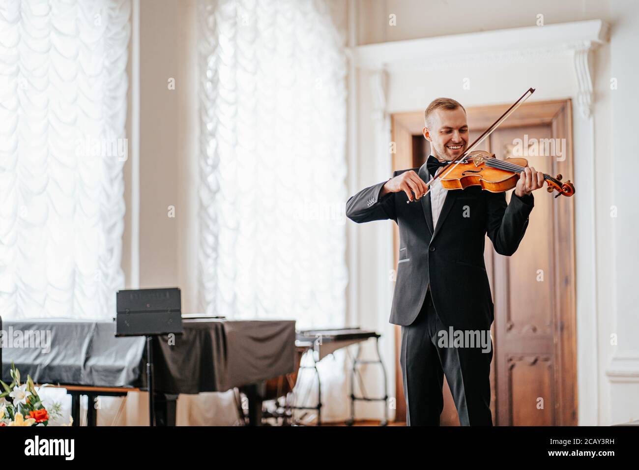 handsome talented violinist in suit play on classic musical instrument ...
