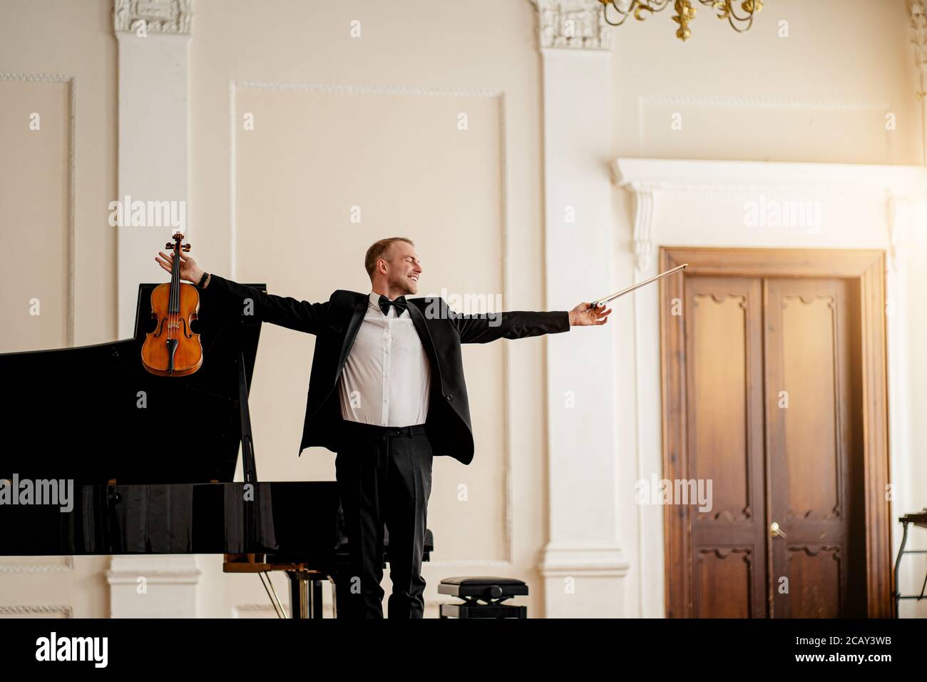 handsome caucasian male violinist in suit in the end of performance ...
