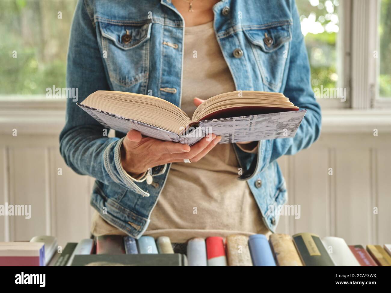 Closeup on woman hands holding open book in bookshop Stock Photo - Alamy