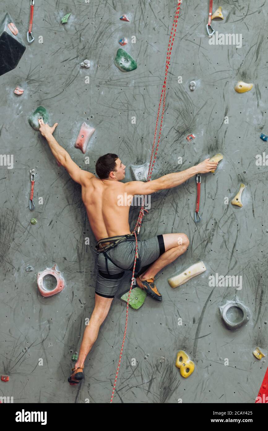 young man hugging the wall, full length photo. rare view Stock Photo ...