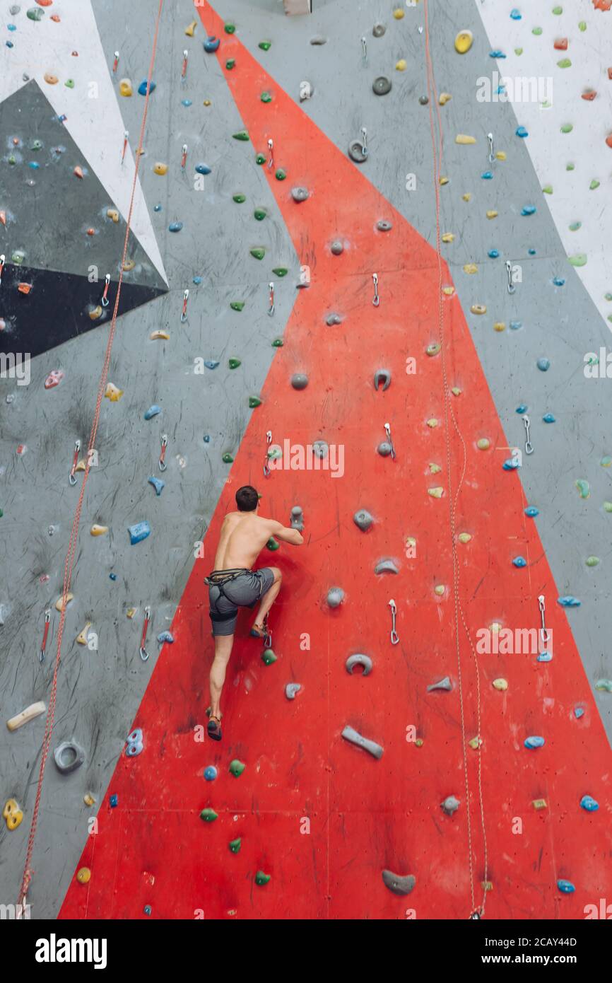 strong man enjoying rock climbing in the. sport center. athlete trying ...