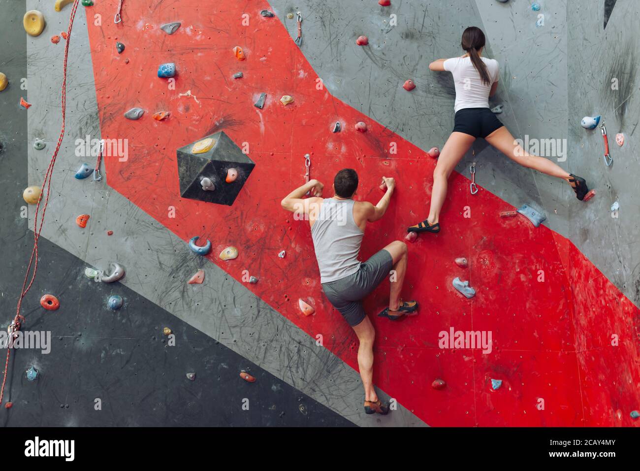 Strong and muscular couple trying new activity in clymbing gym. Sporty ...