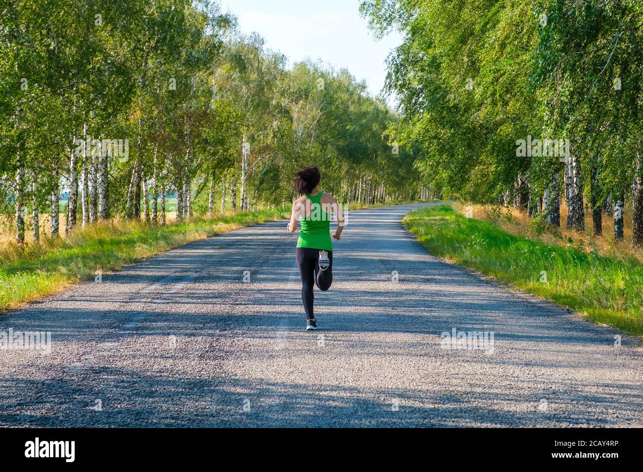 Woman running road rear view hi-res stock photography and images - Alamy