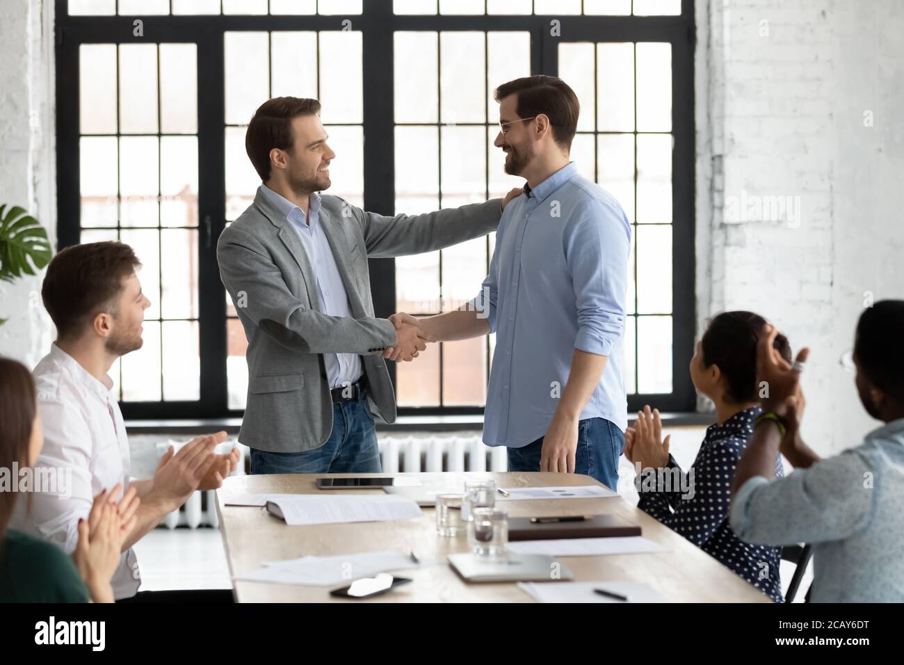 Smiling executive shaking successful employee hand, congratulating with ...