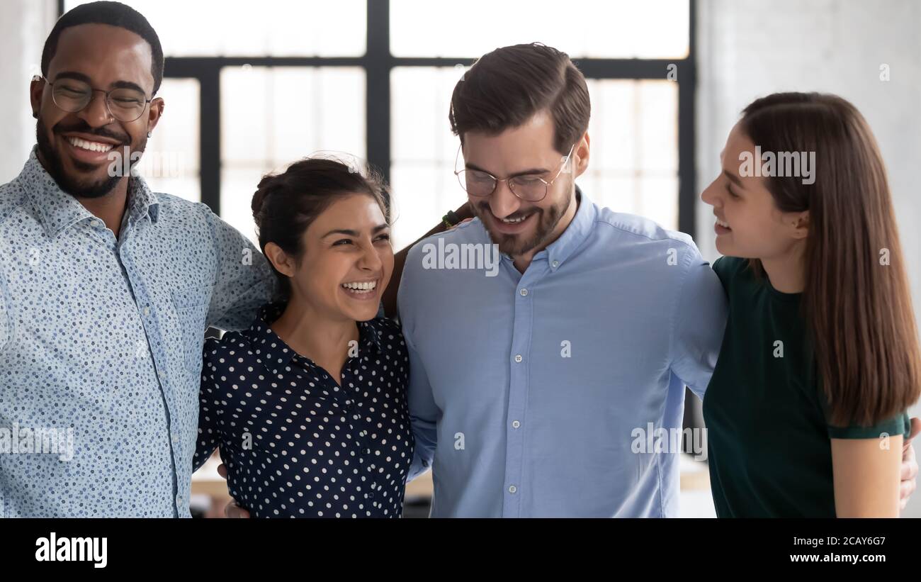 Close up happy diverse employees hugging, celebrating success Stock ...