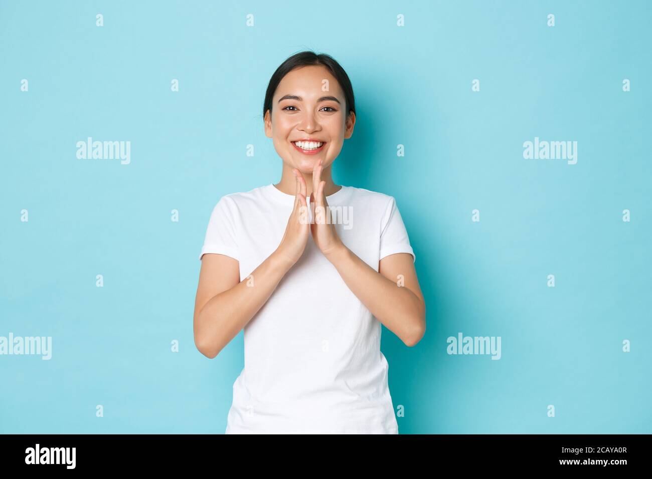 Charming happy asian female in white t-shrit smiling satisfied ...