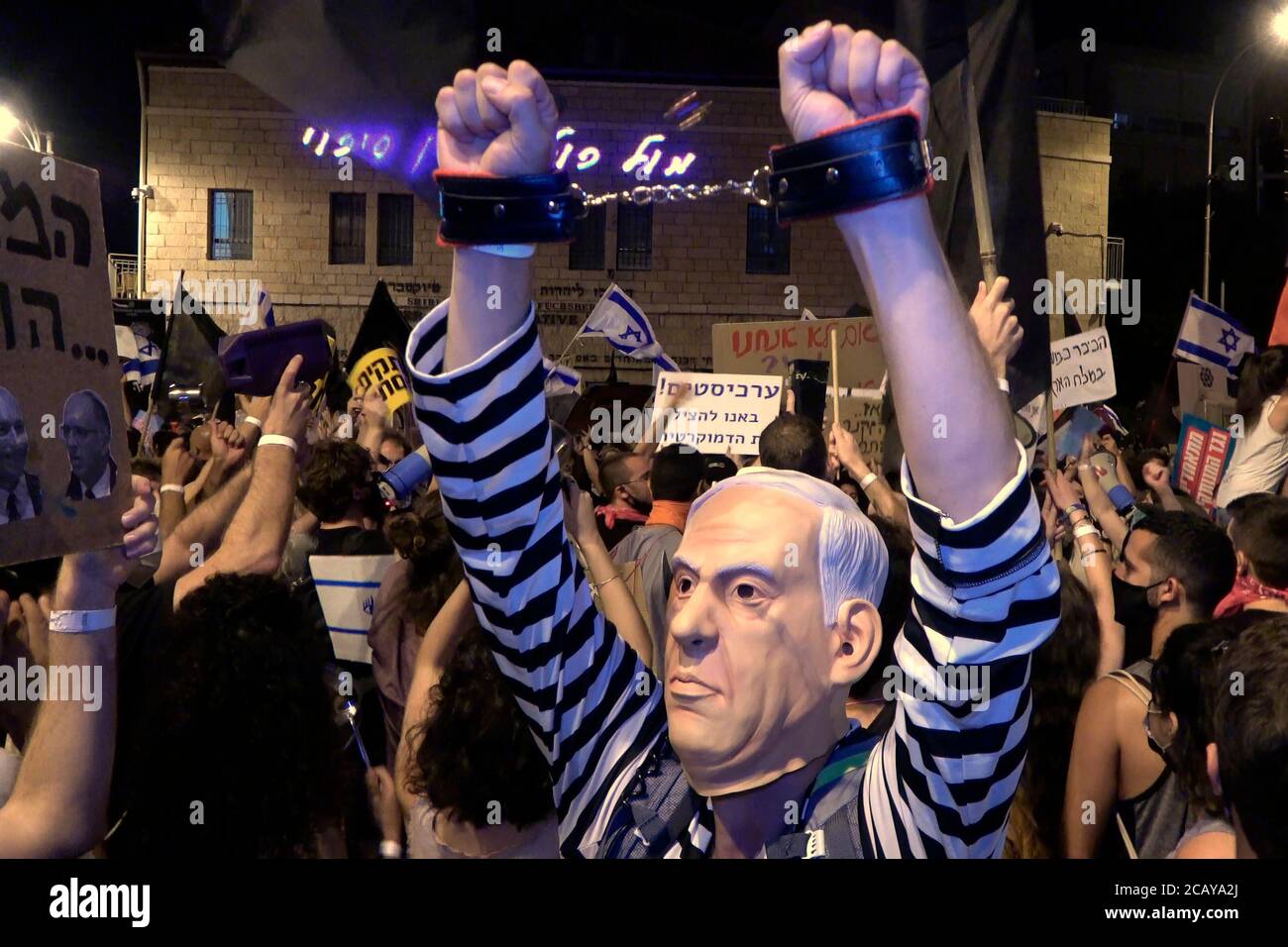 An Israeli protester wearing a mask with the effigy of Prime Minister ...