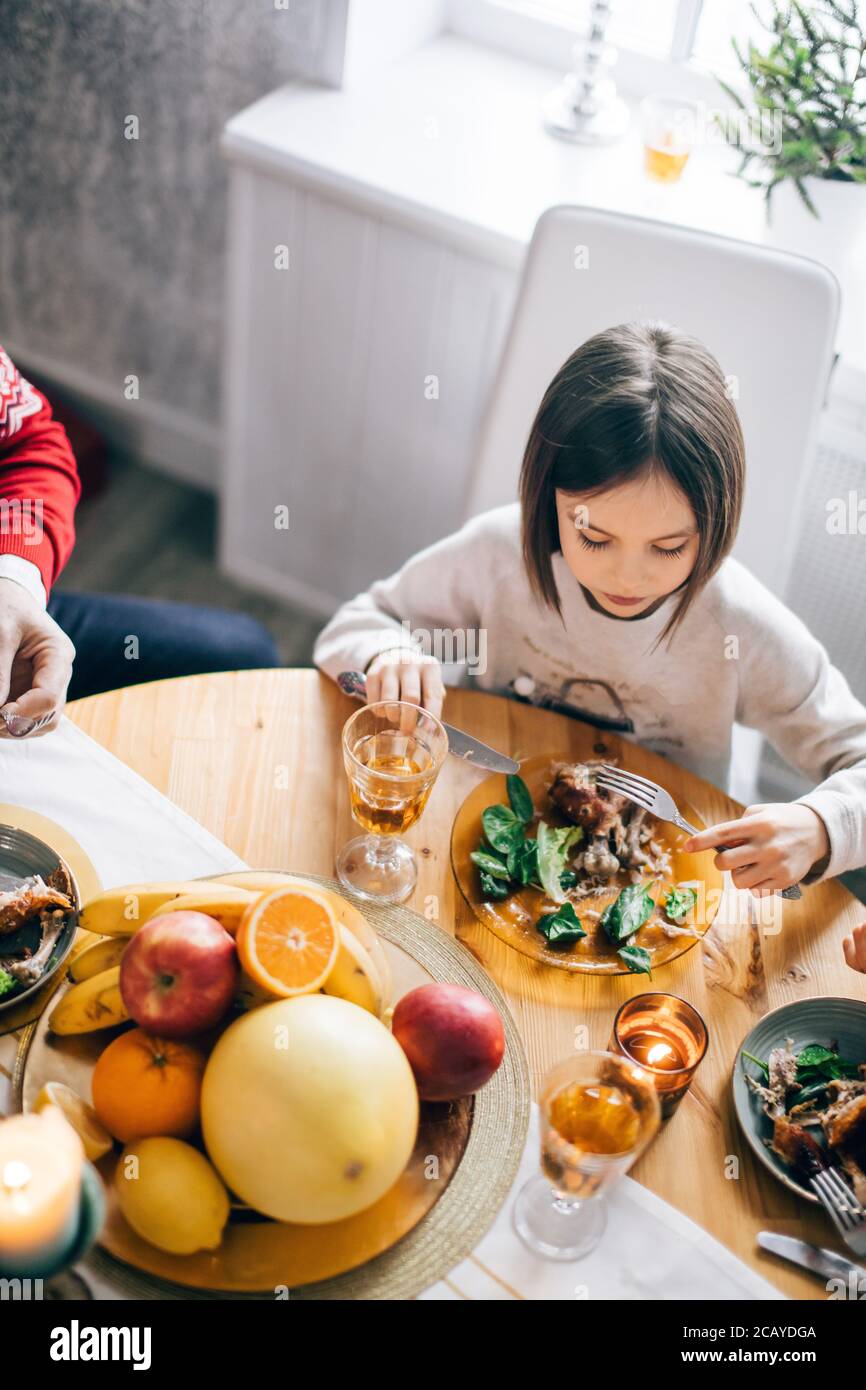 top angle view, adorable daughter having dinner with relatives. child ...