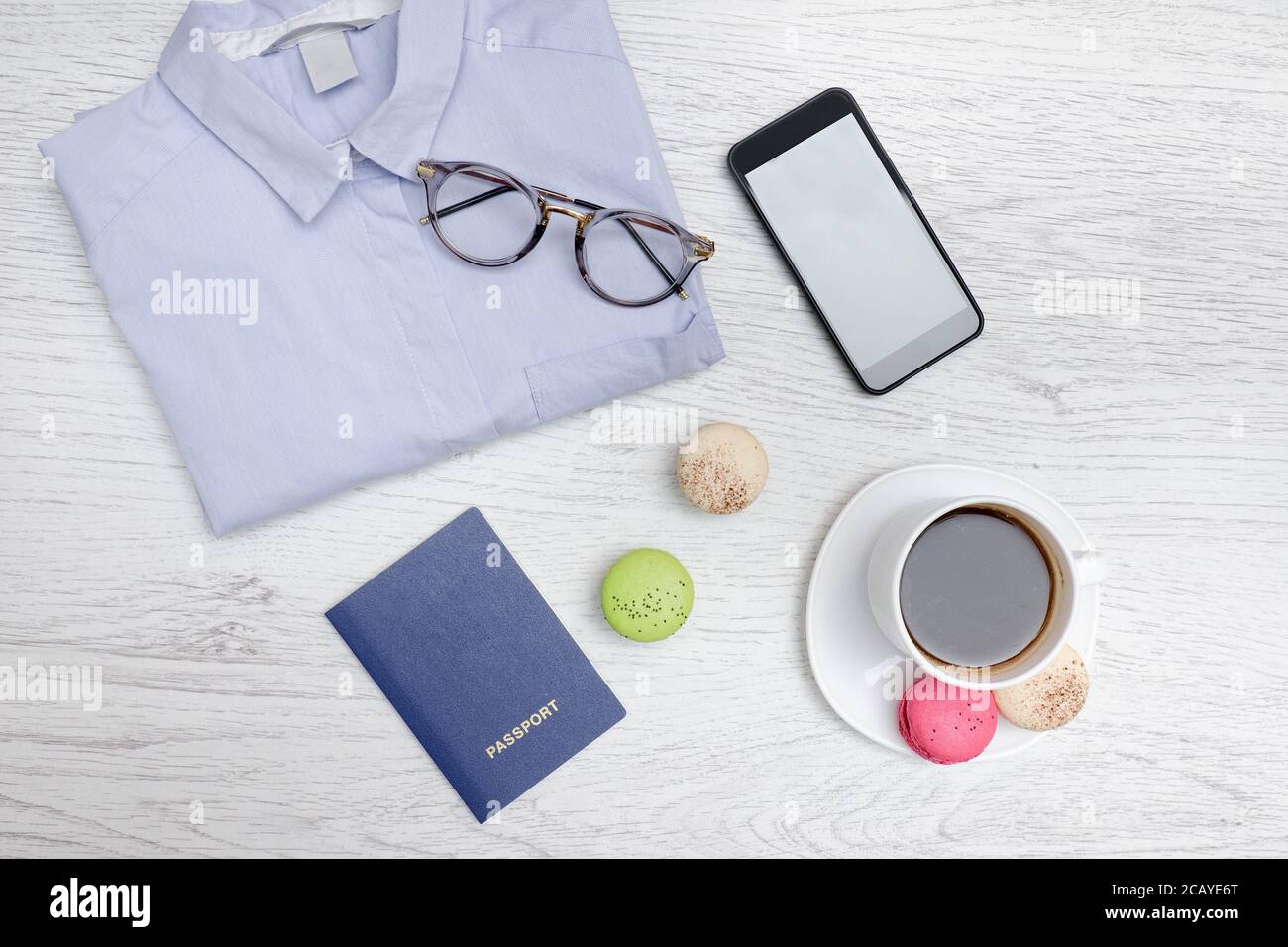 Passport, coffee mug, smart phone and shirt with glasses. Travel ...
