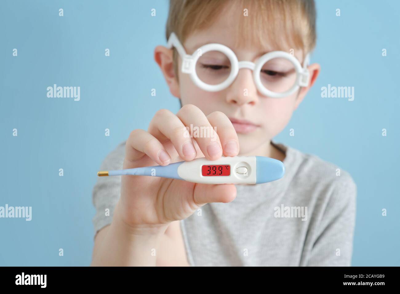 Little boy with a thermometer in his hand. Increased body temperature ...