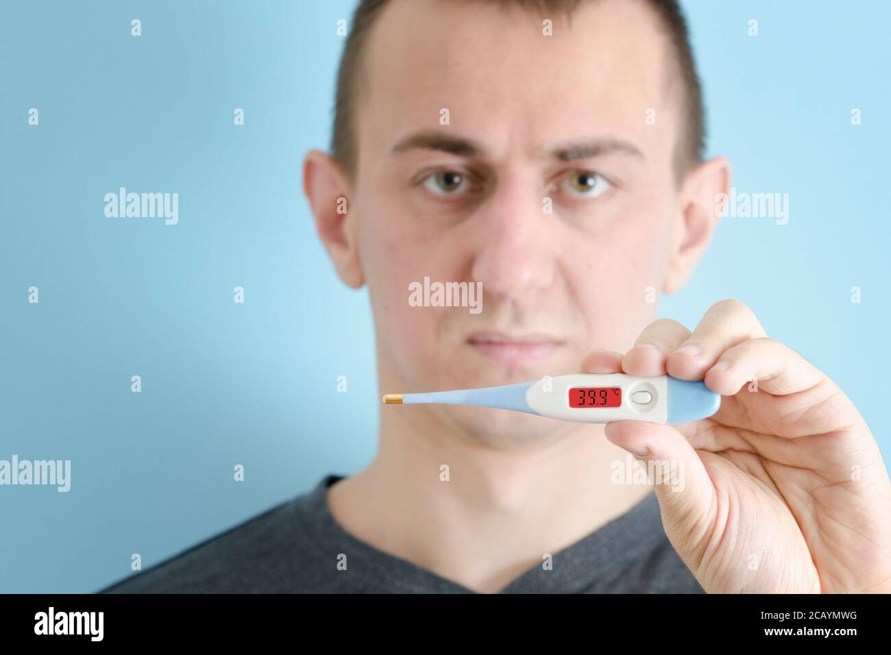Man with a thermometer in his hand. High body temperature Stock Photo ...