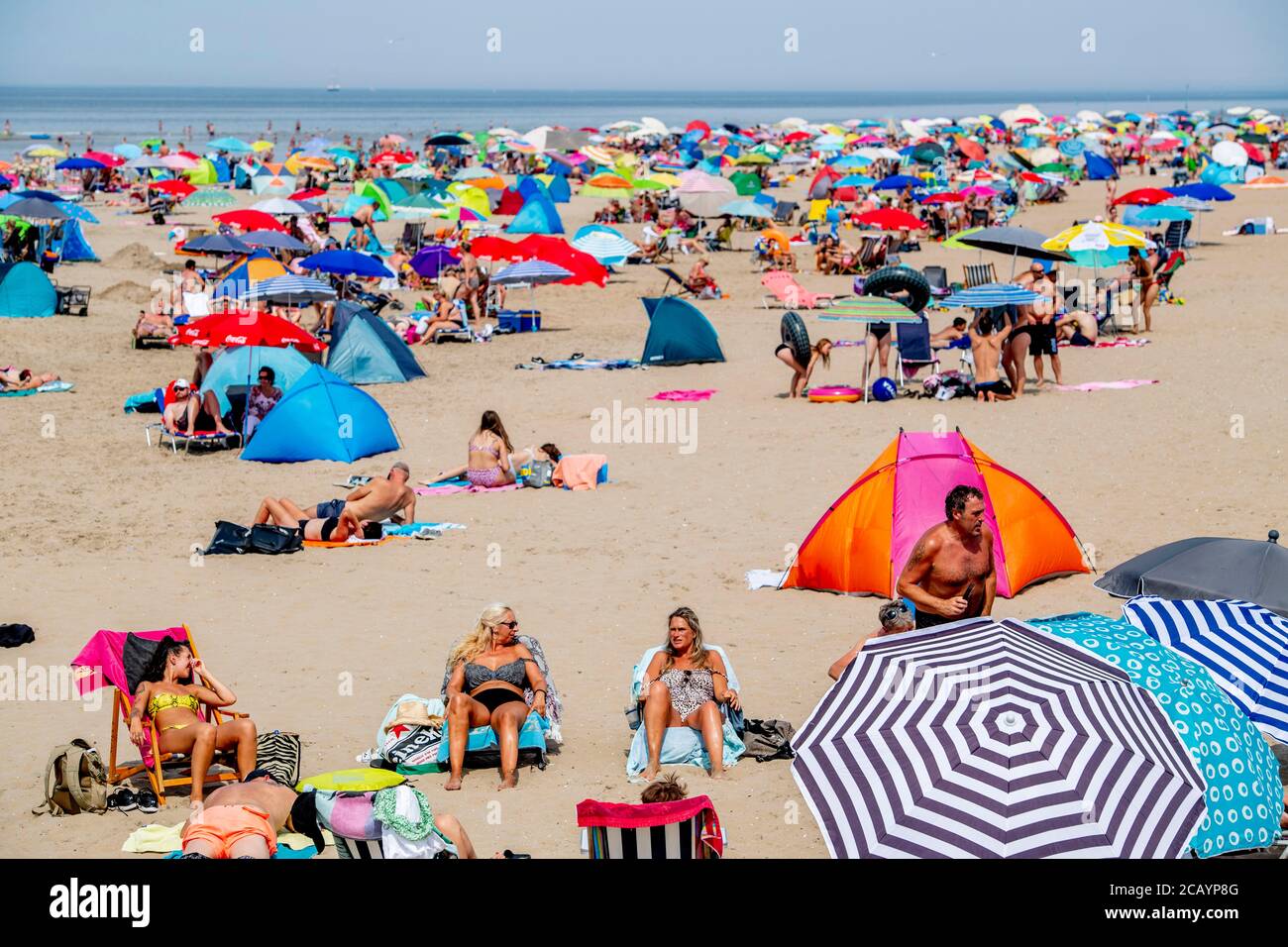 The beach is busy and completely full as people cool off enjoying the ...