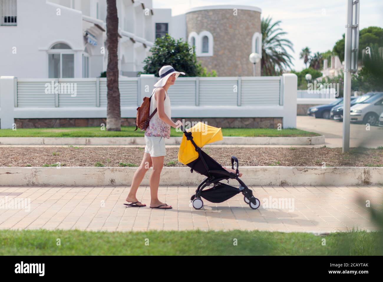 Young mother pushing stroller with sleeping baby outdoors Stock Photo ...