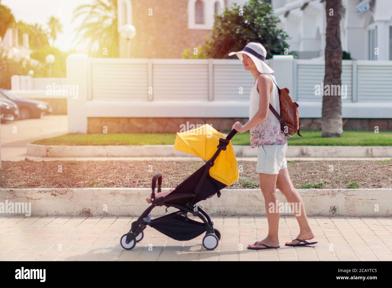 Young mother pushing stroller with sleeping baby outdoors Stock Photo ...