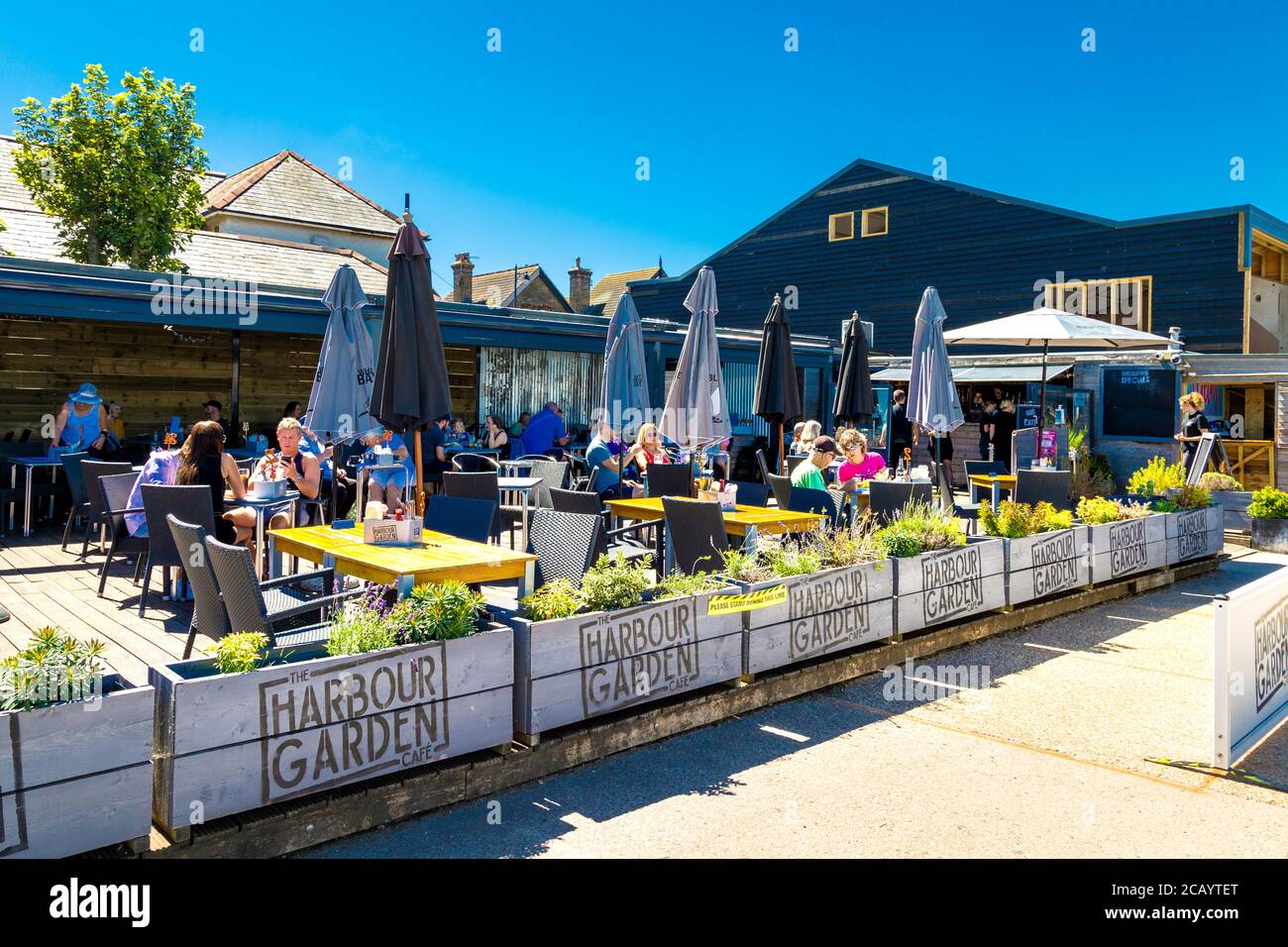 People dining al fresco at The Harbour Garden Cafe in seaside town ...