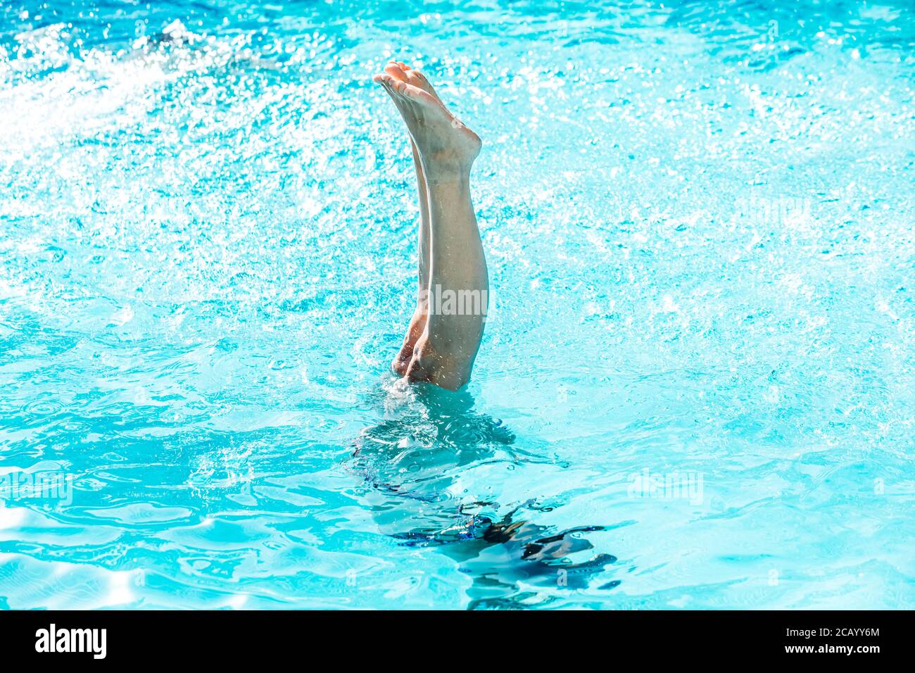Woman submerged in a pool doing a handstand Stock Photo - Alamy