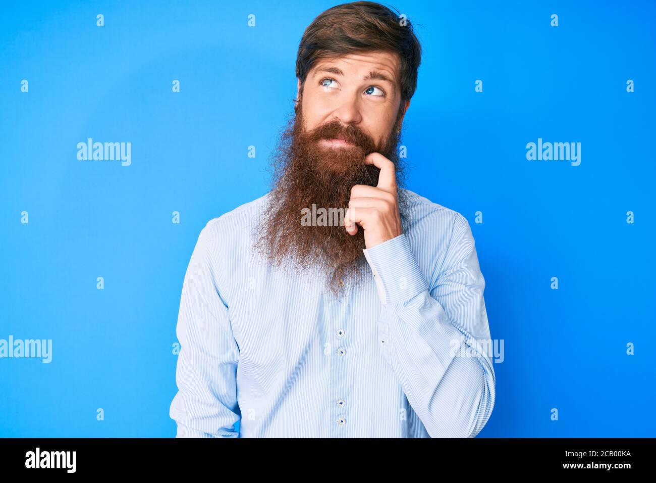 Handsome young red head man with long beard wearing elegant clothes ...