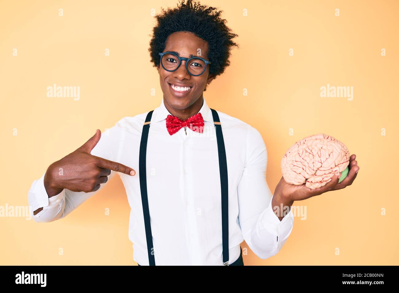 Handsome african american nerd man with afro hair holding brain ...