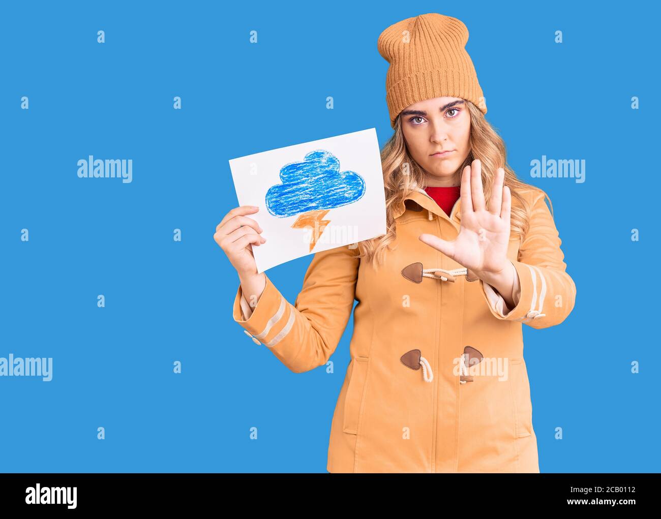 Young caucasian woman holding thunder draw with open hand doing stop ...