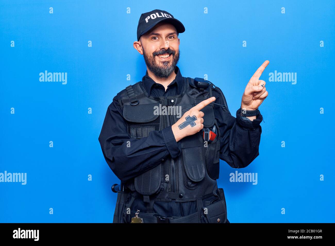 Young handsome man wearing police uniform smiling and looking at the ...