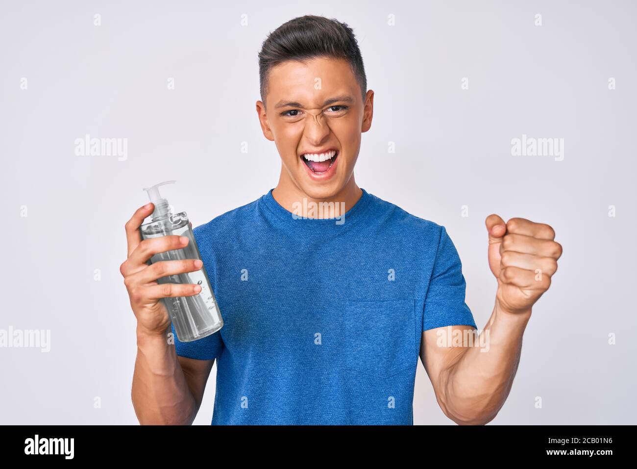 Young hispanic boy using hand sanitizer gel screaming proud ...