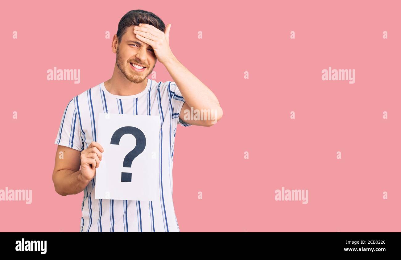 Handsome young man with bear holding question mark stressed and ...